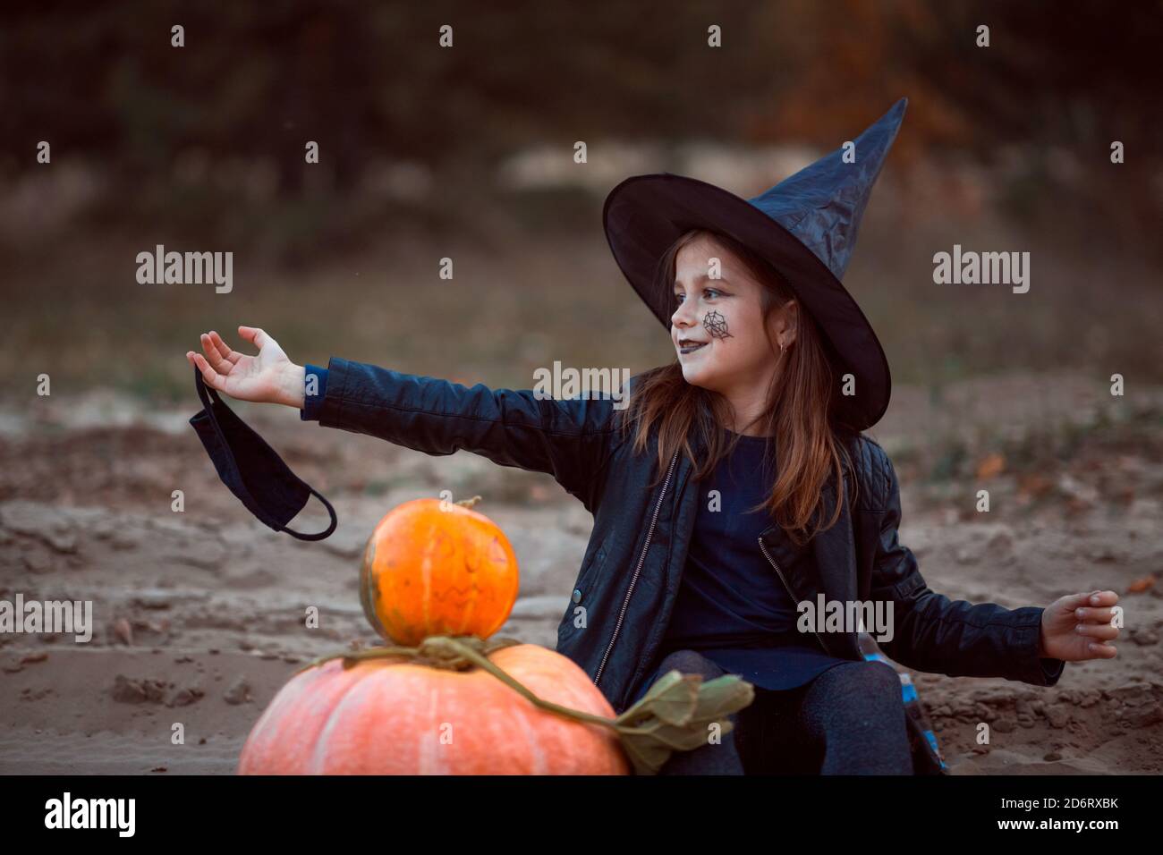 A cute girl in a Halloween costume is holding a medical face mask Stock ...
