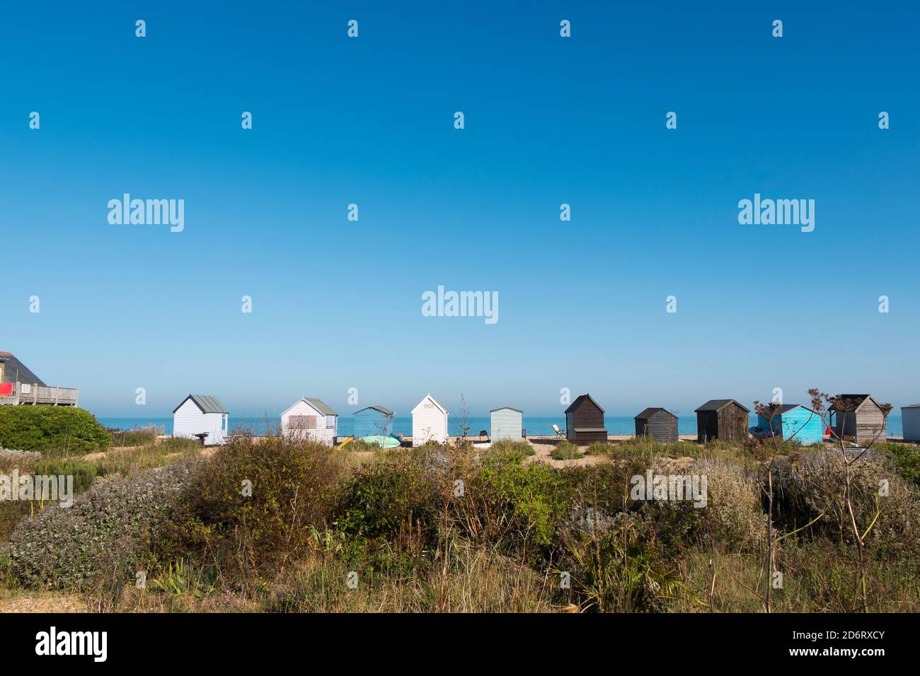 A row of beach huts across the wild flora along the beach at Kingsdown ...
