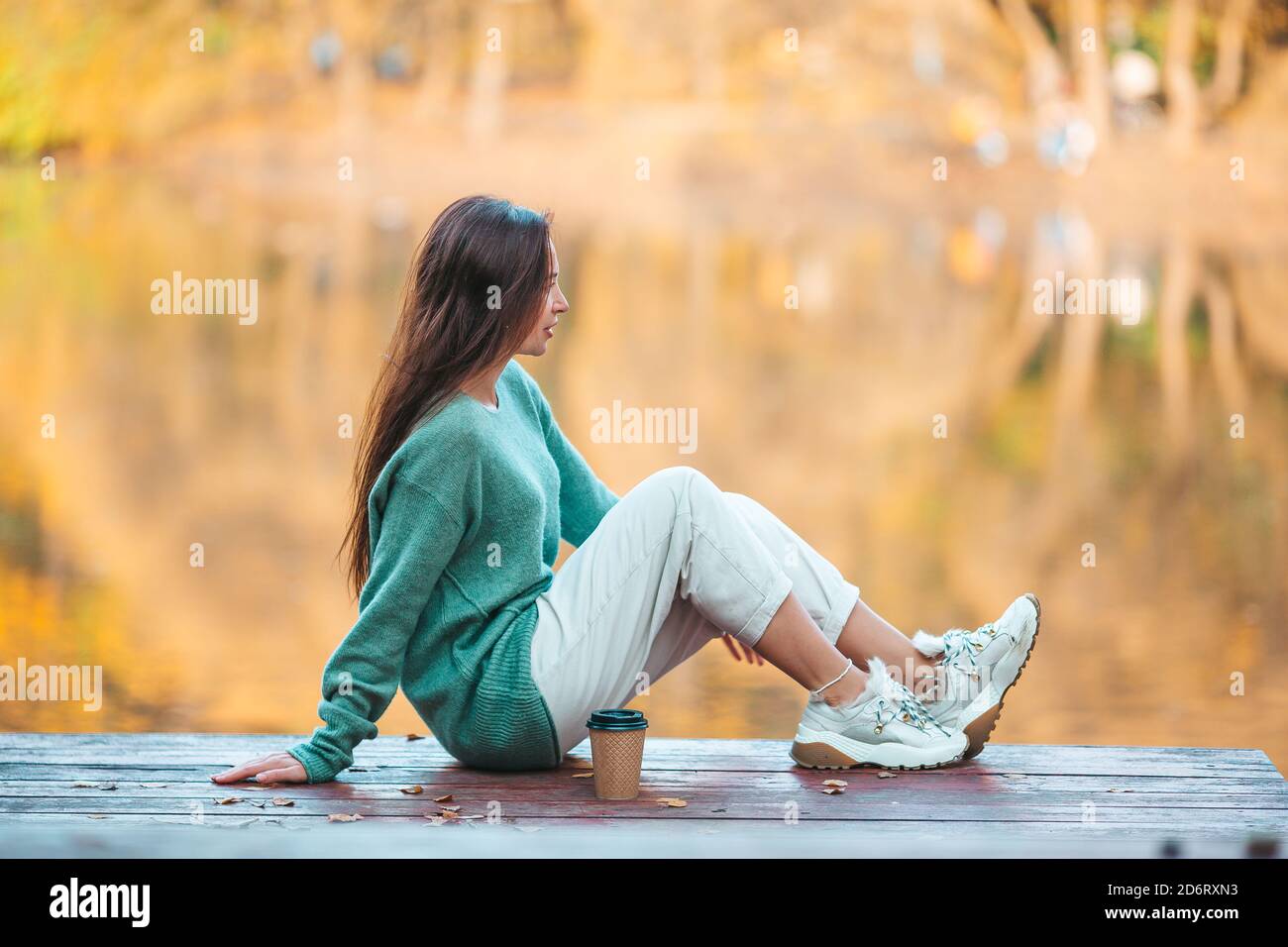 Fall concept - beautiful woman drinking coffee in autumn park under ...