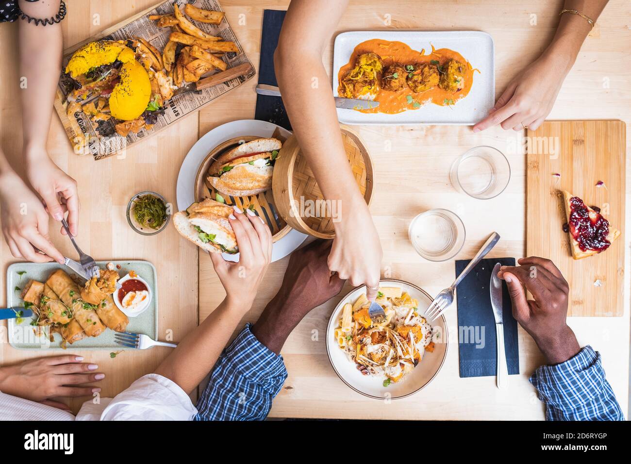 Top view crop multiethnic friends gathering at table in modern ...