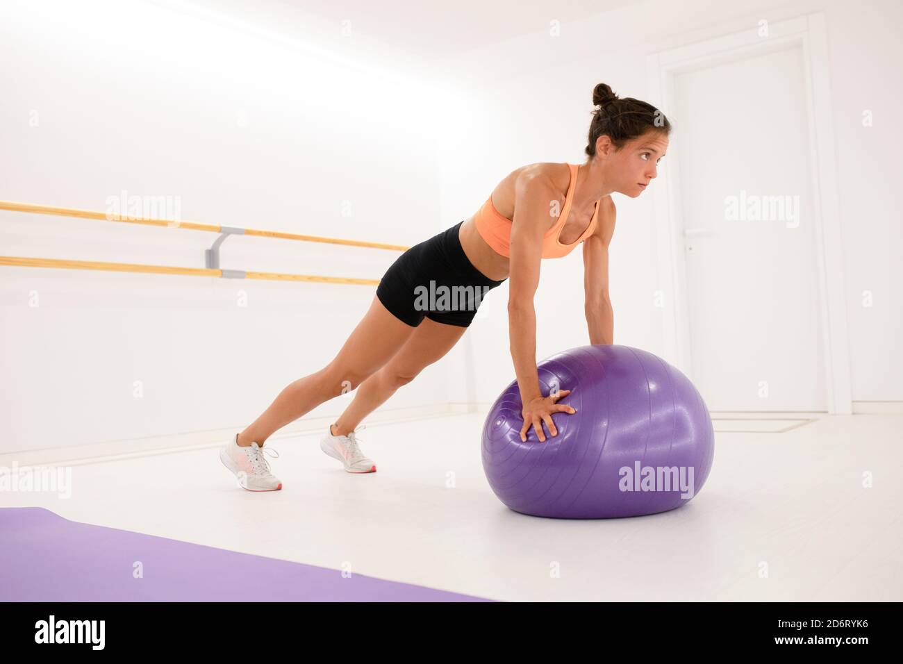 Side view of young fit focused athlete in sports clothes using fitness ...