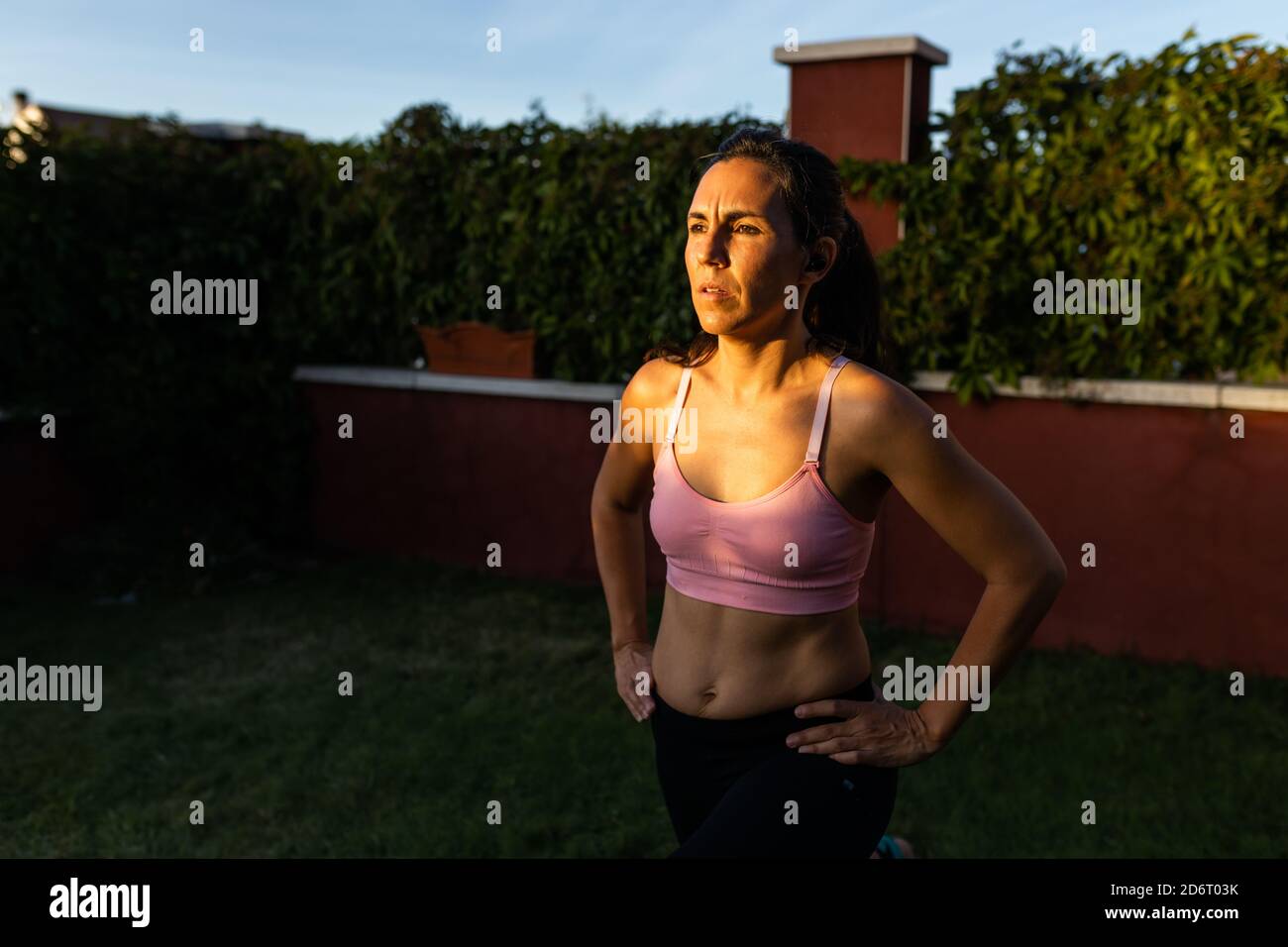 Fit female athlete in sportswear using laptop and doing lunges while ...