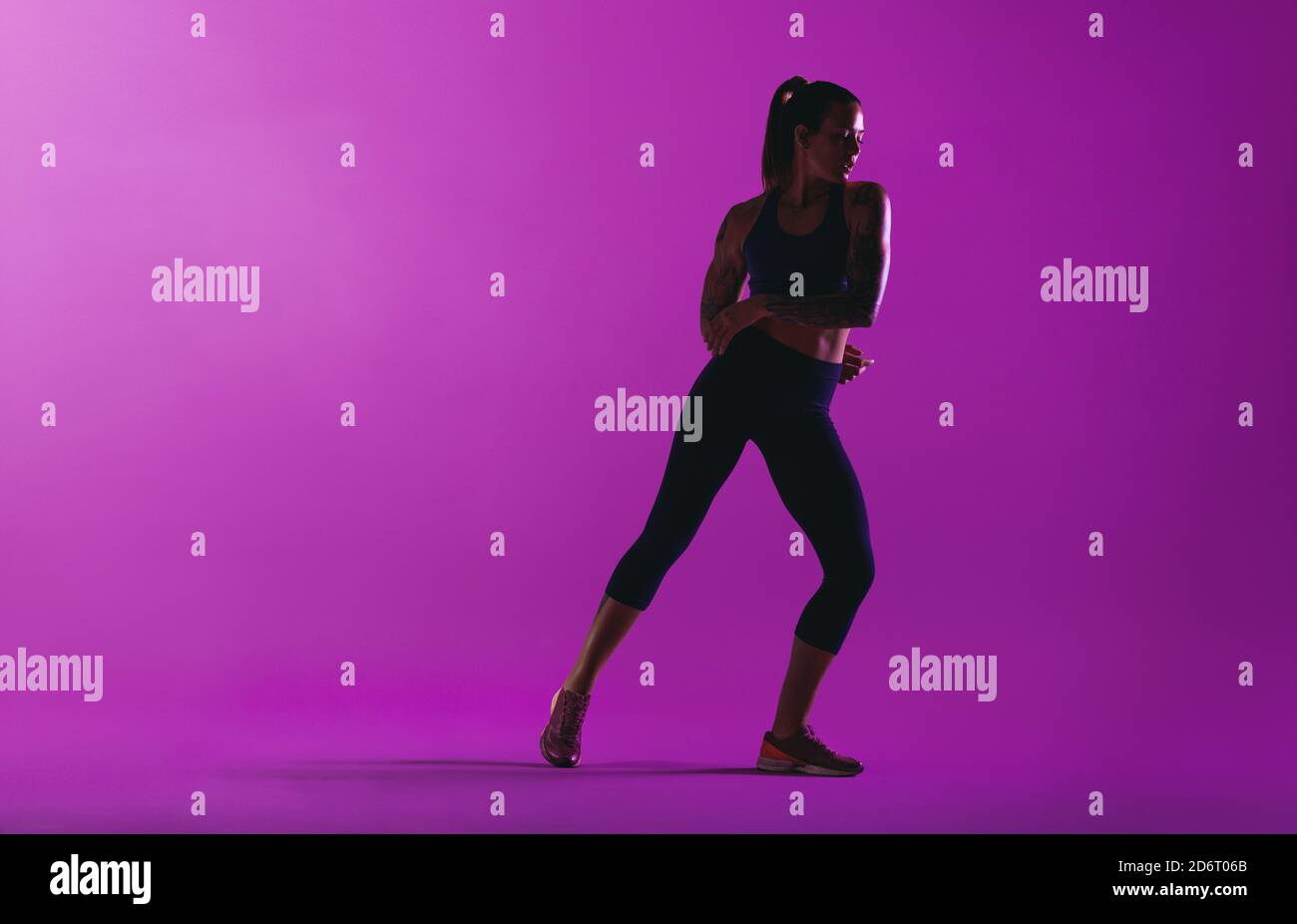 Portrait of fitness woman working out on purple background. Woman in ...