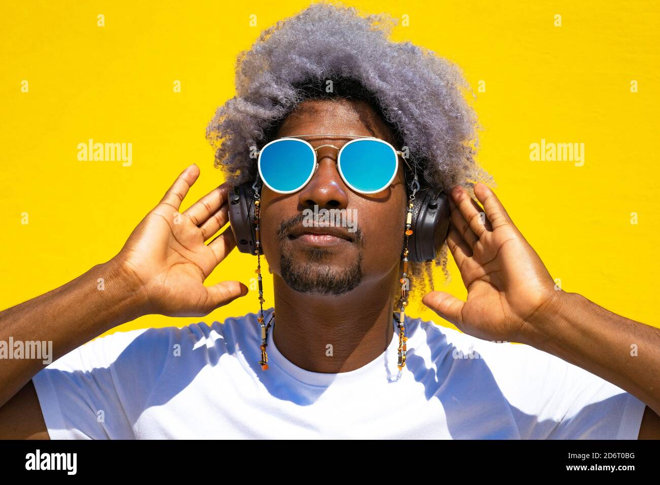 Black man with afro hair and sunglasses putting on headphones. Concept ...