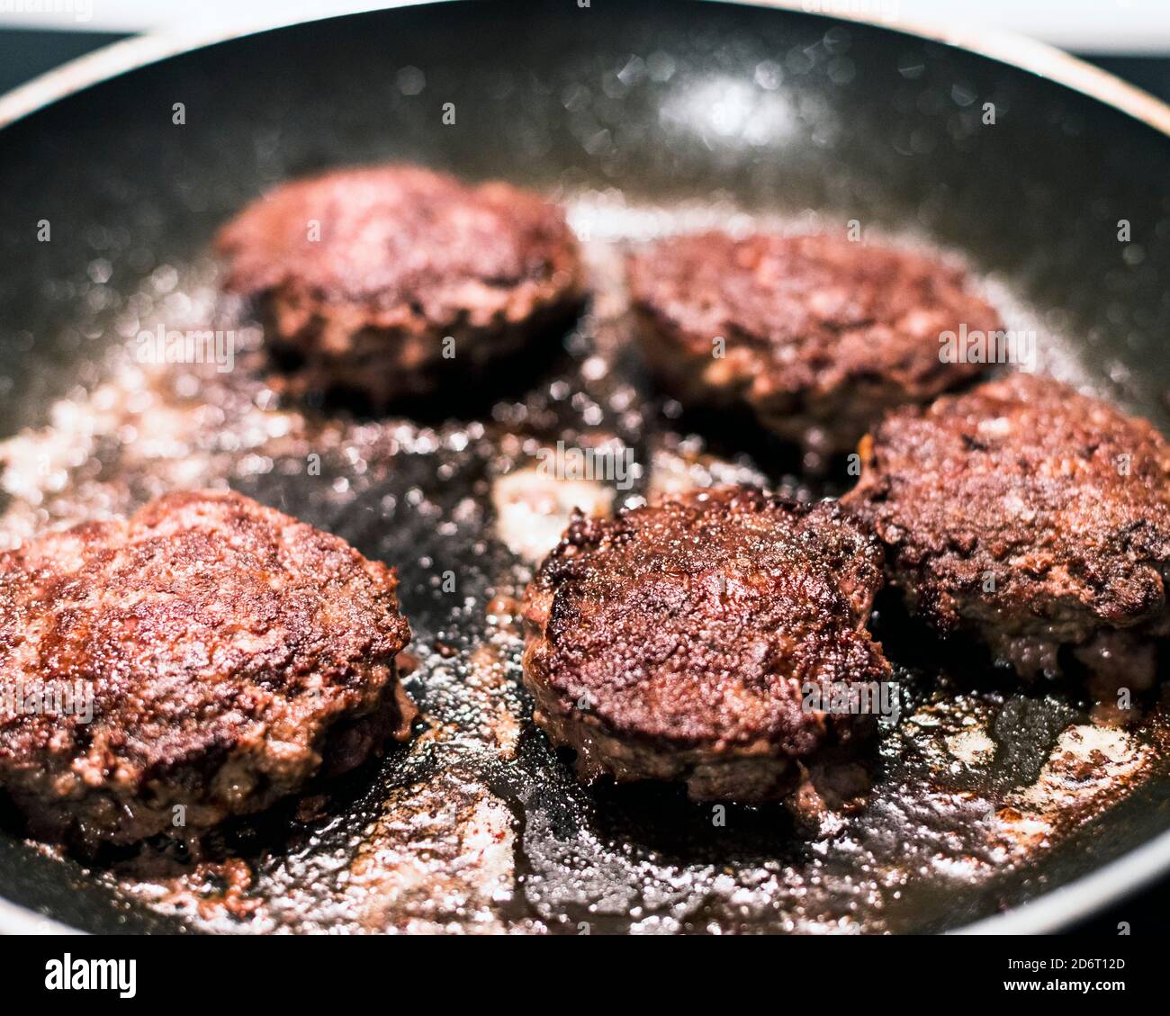 Hamburgers in a frying pan Stock Photo - Alamy