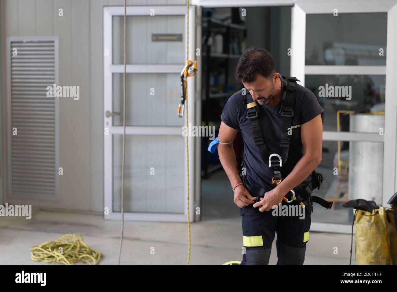 Bearded fireman putting on belt while preparing for routine practices ...