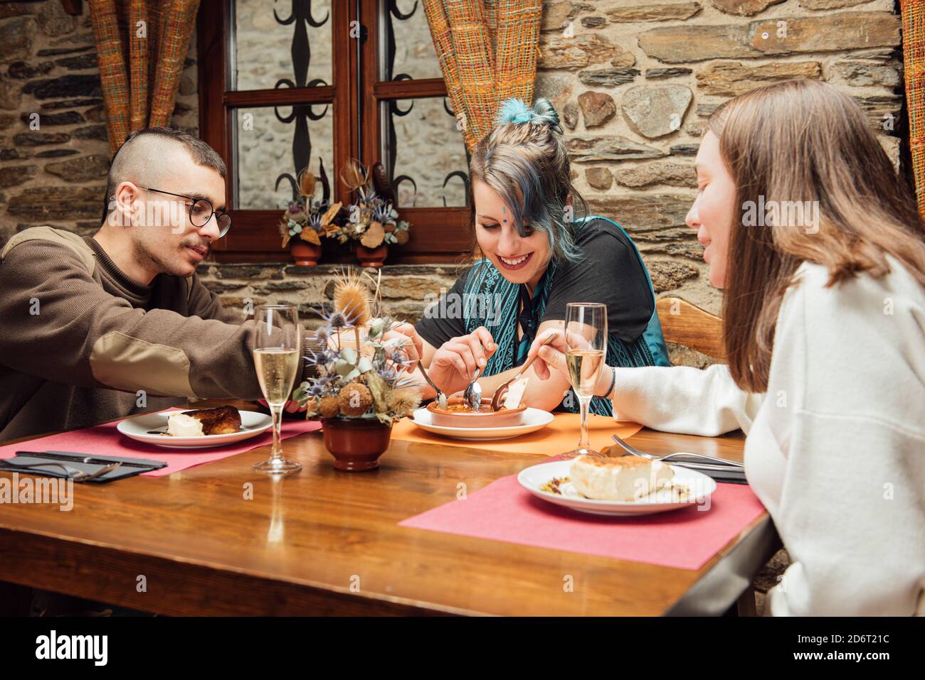 Front view of group of hipsters sitting together at table in restaurant ...