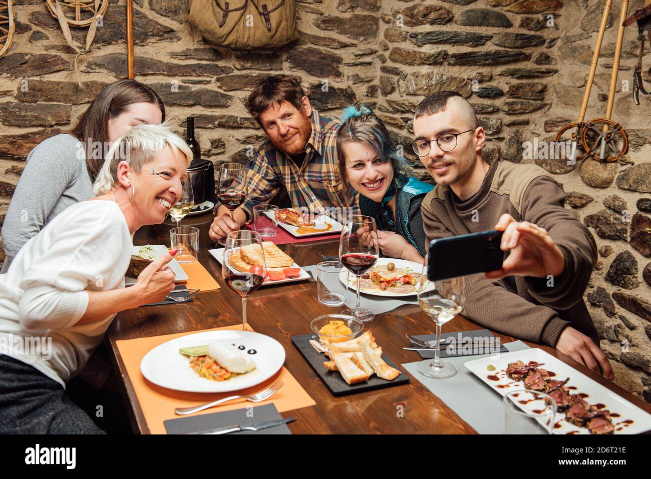 Cheerful friendly hipsters sitting together in cafe and taking picture ...