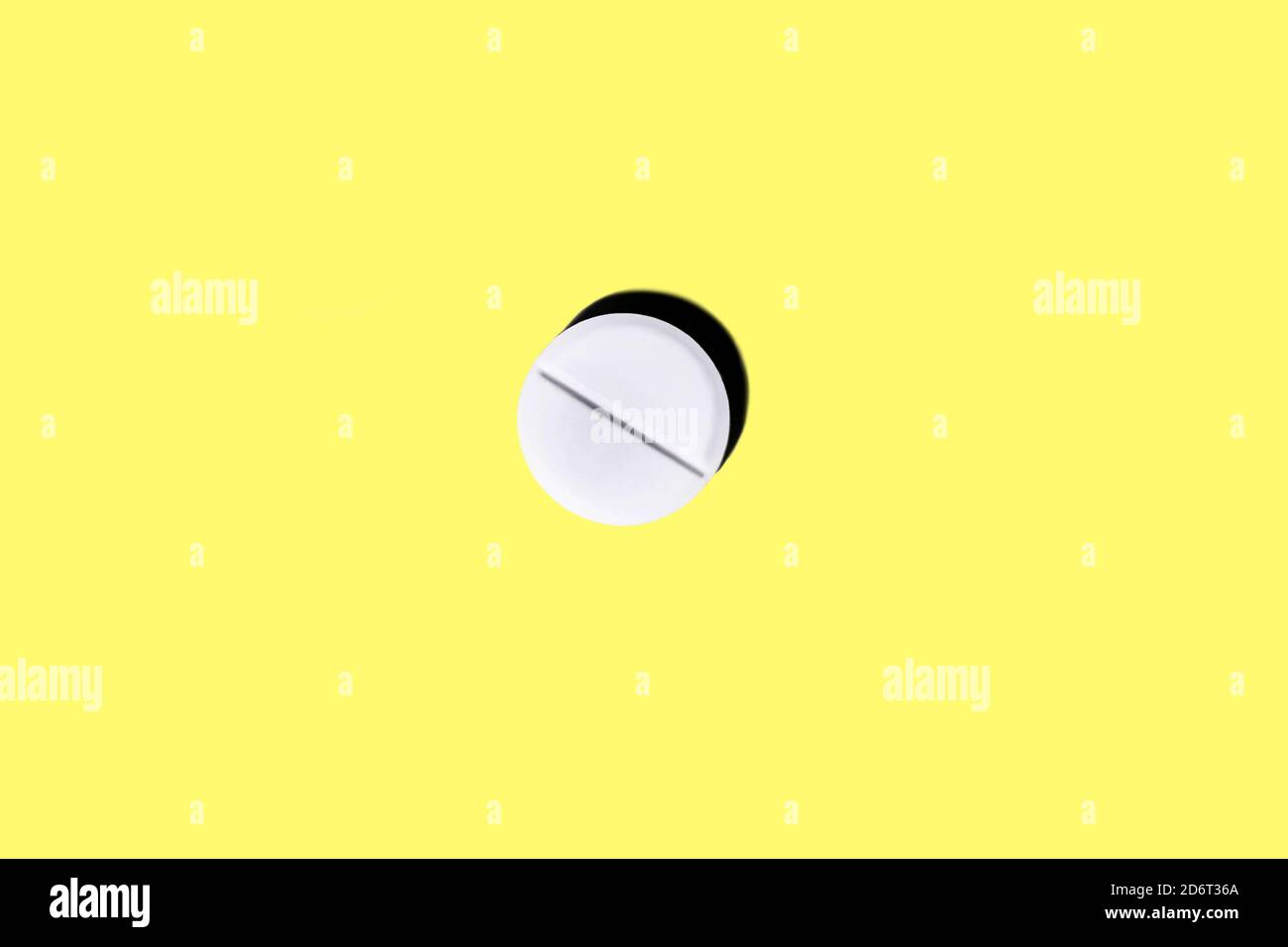 white round tablet on a yellow background Stock Photo - Alamy