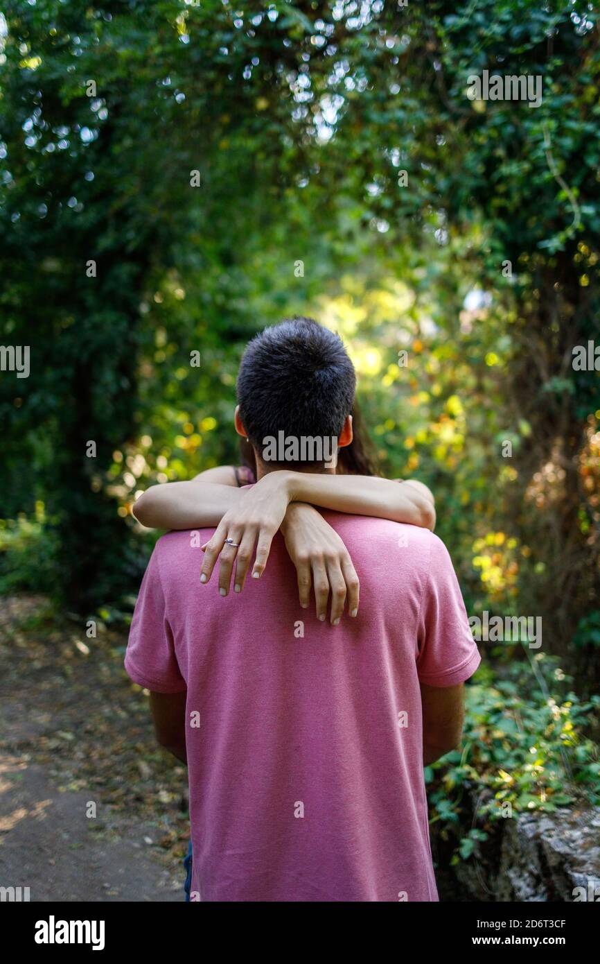 Back view unrecognizable man embracing girlfriend while standing face ...