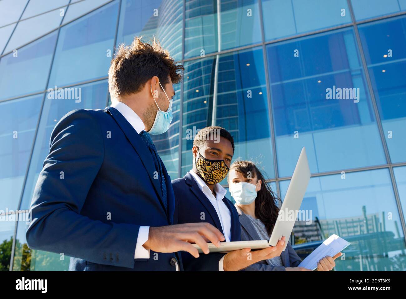 Crop of anonymous diverse coworkers working on laptop in formal suit ...