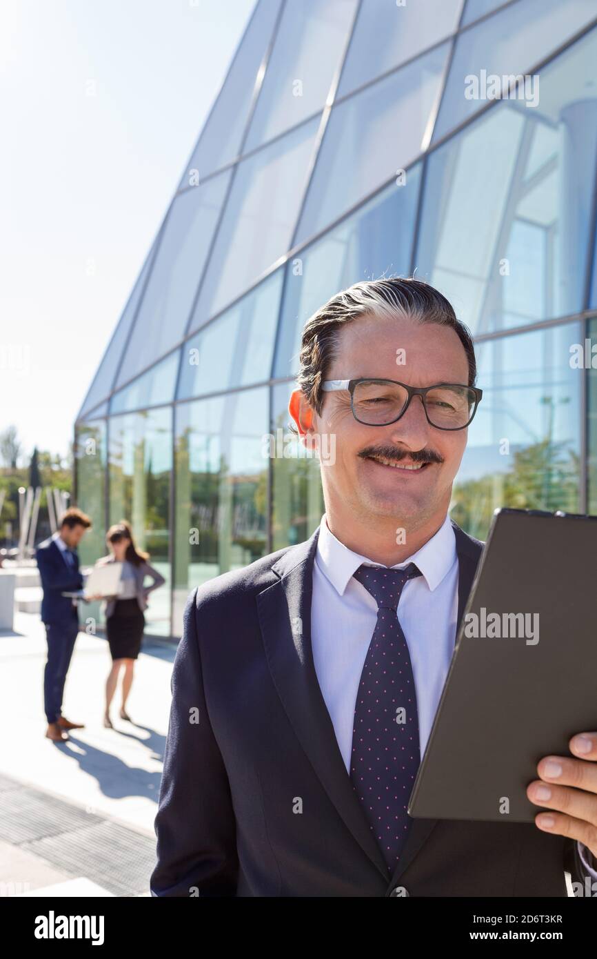 Happy middle aged male manager with mustache in classy outfit holding ...