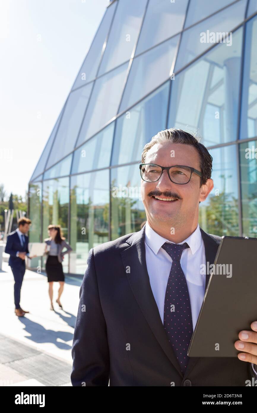 Happy middle aged male manager with mustache in classy outfit holding ...