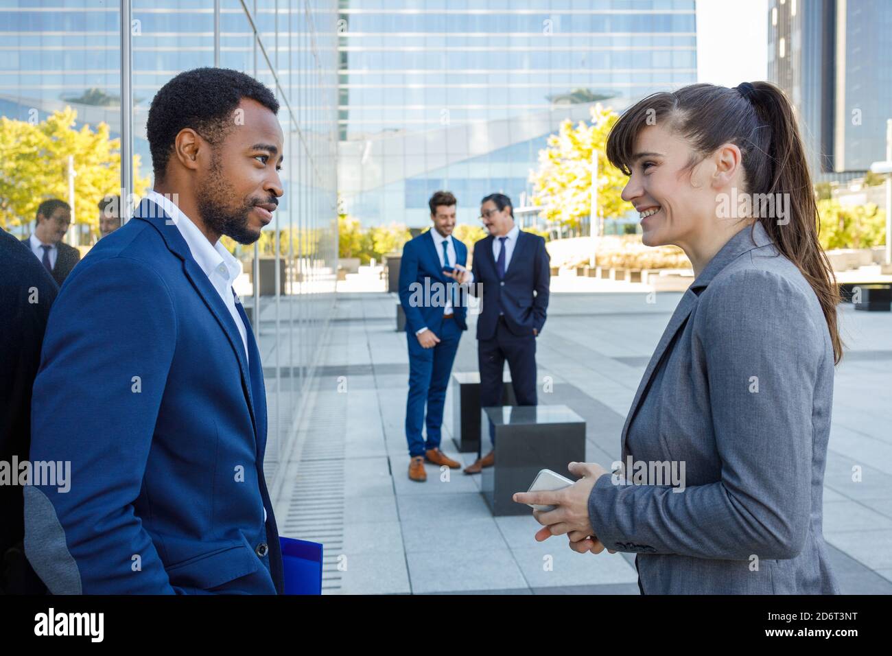Side view of young positive multiracial colleagues in classy suits ...