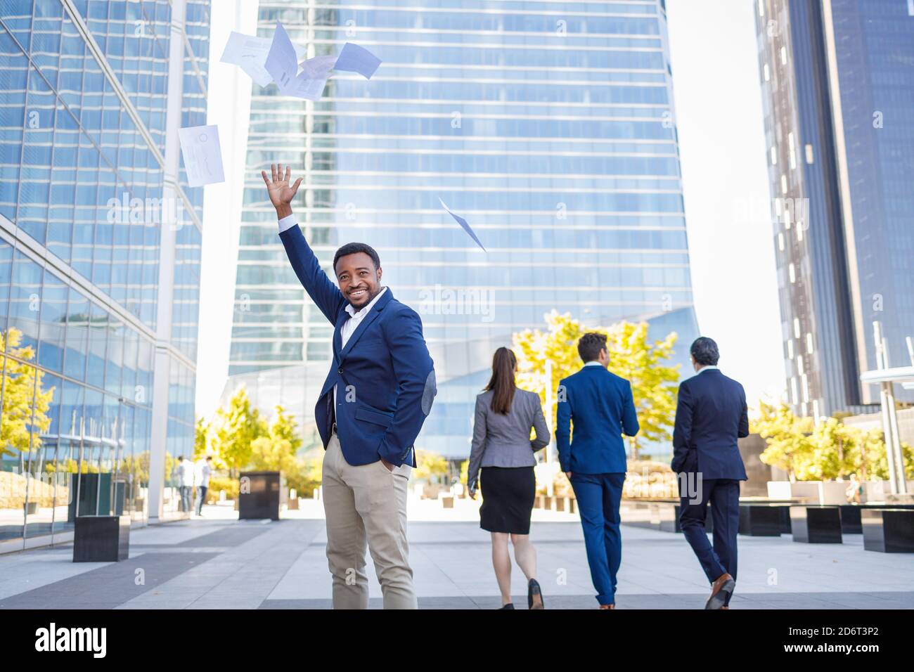 Cheerful young black male manager in elegant suit throwing papers on ...