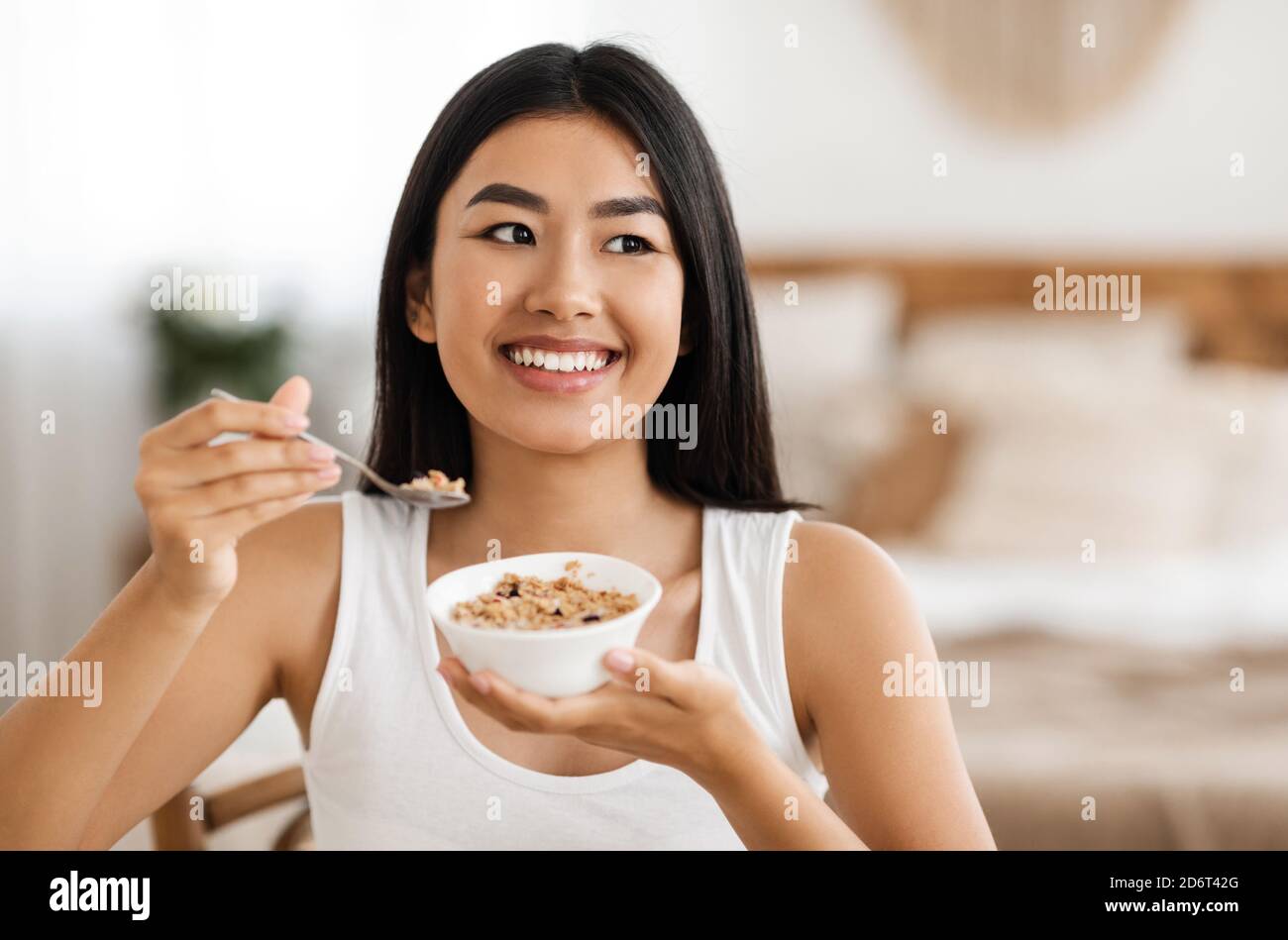 Woman eating oatmeal indoors hi-res stock photography and images - Alamy