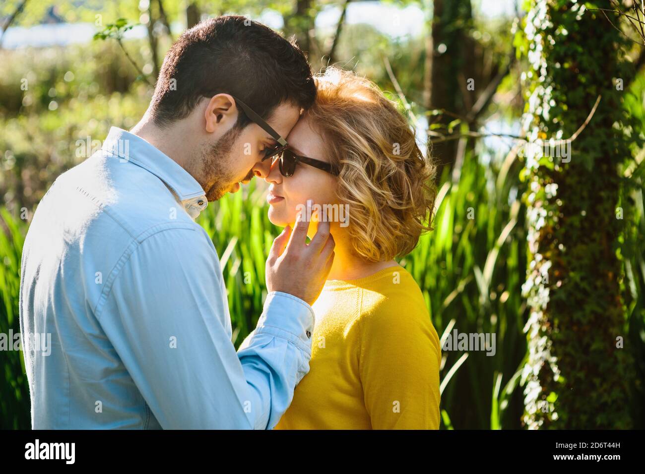 Side view of calm man tenderly touching cheek of Woman while standing ...