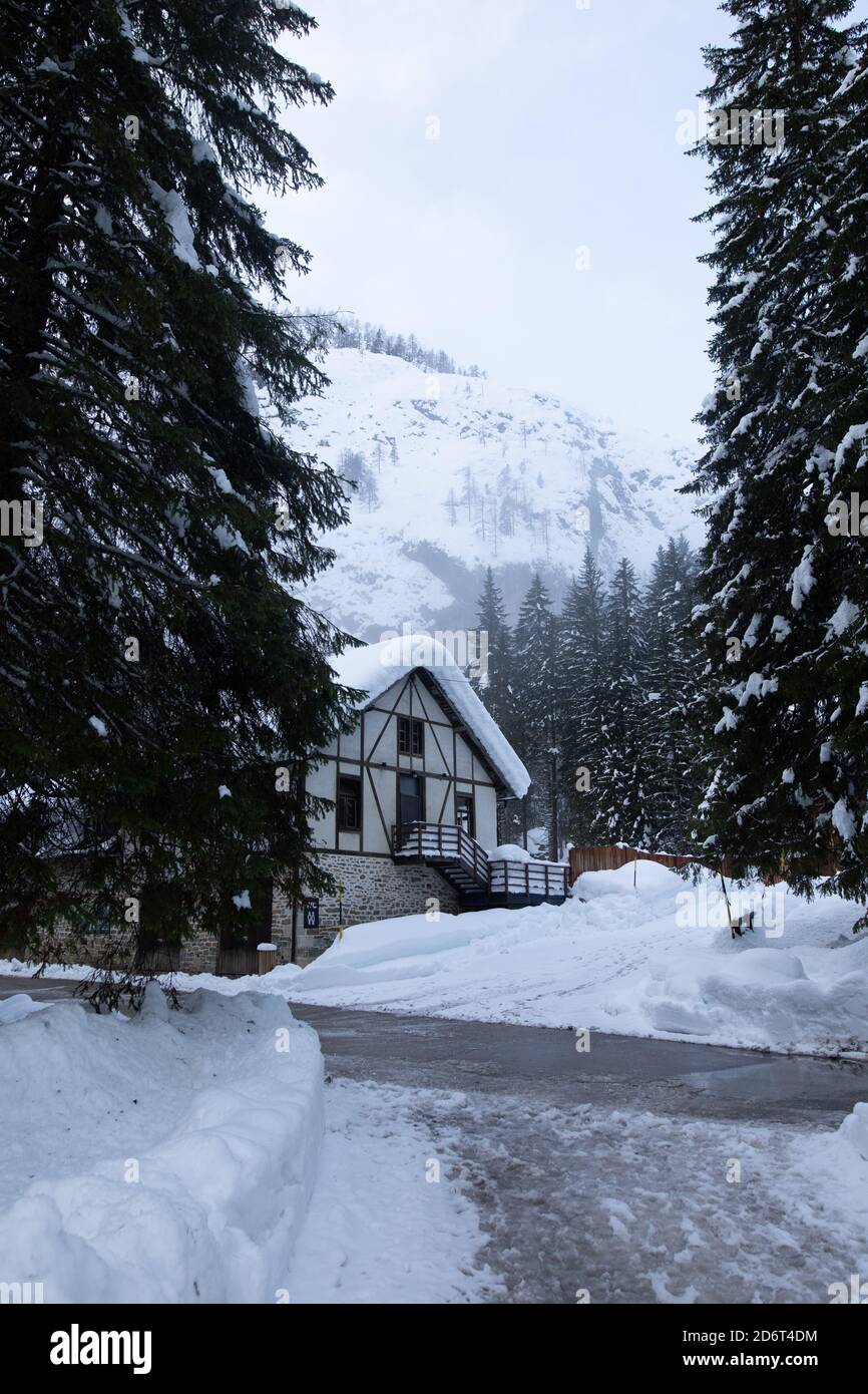 Cold winter landscape with lonely stilt house located near frozen river ...