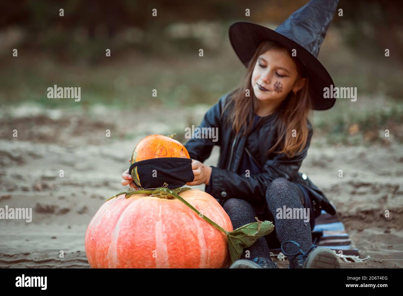 A cute girl in a Halloween costume is holding a medical face mask Stock ...