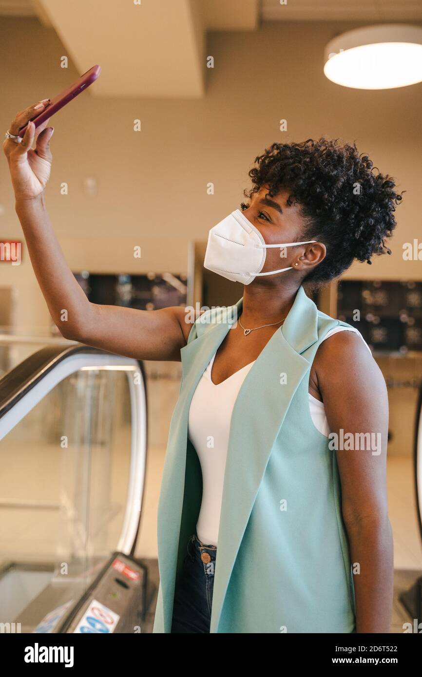 Side view of positive young African American female in casual outfit ...