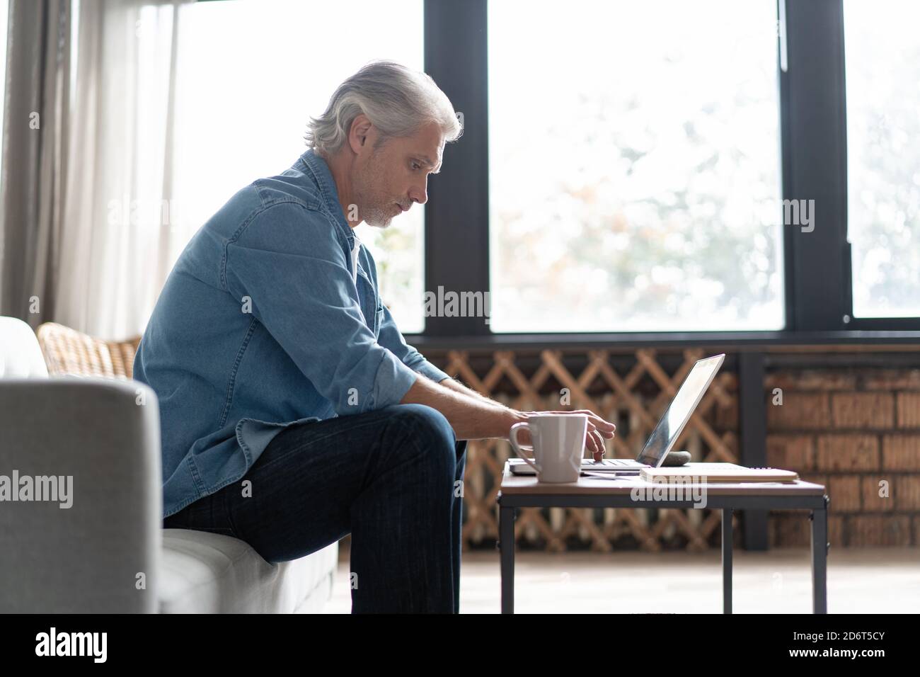 Middle-aged man working from home-office on laptop Stock Photo - Alamy