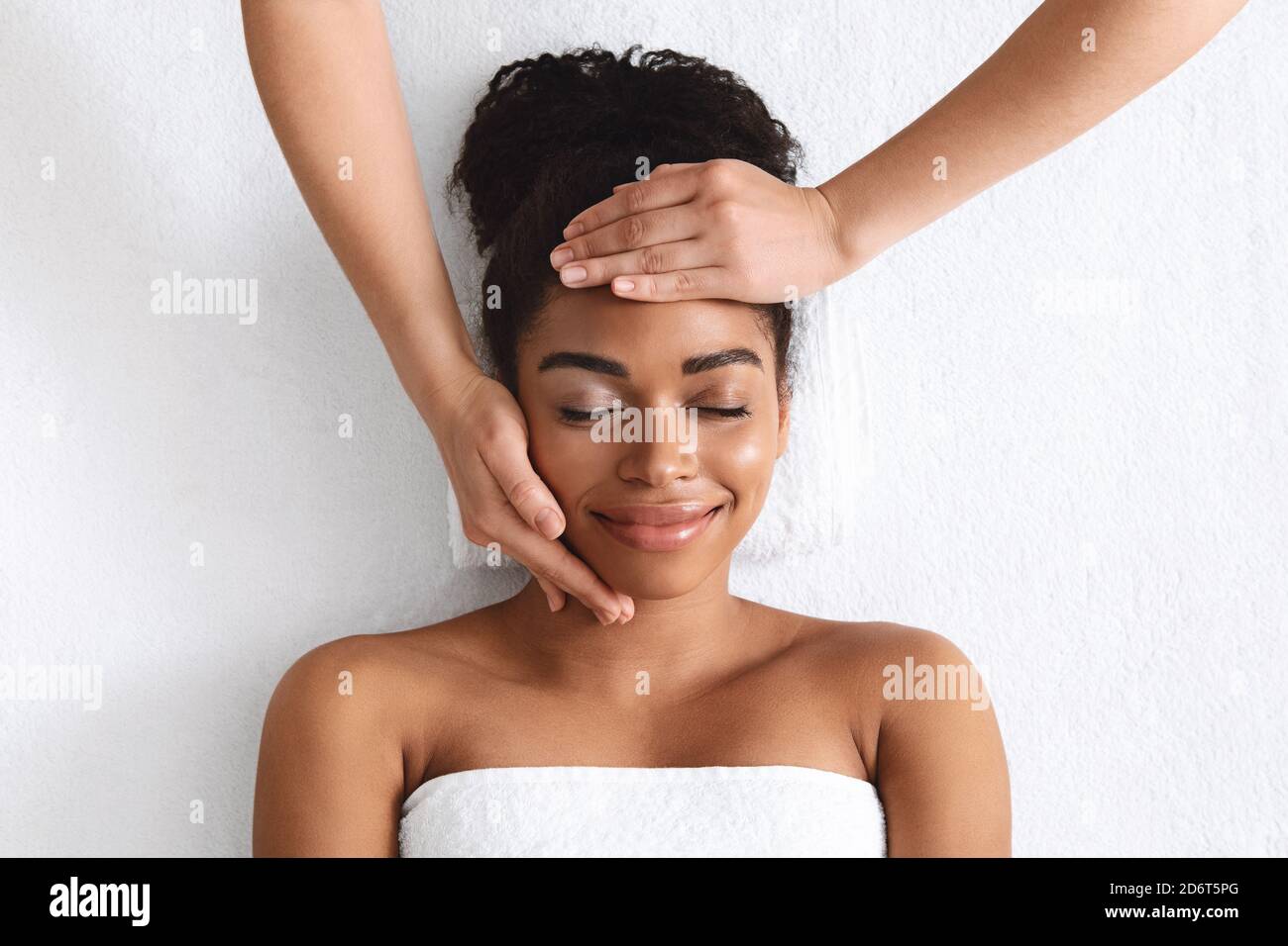 Top view of smiling black lady getting face massage Stock Photo - Alamy