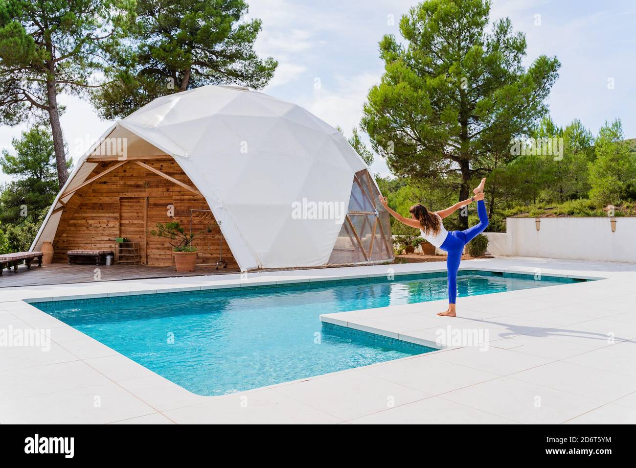 Side view of unrecognizable flexible barefoot female in sportswear ...