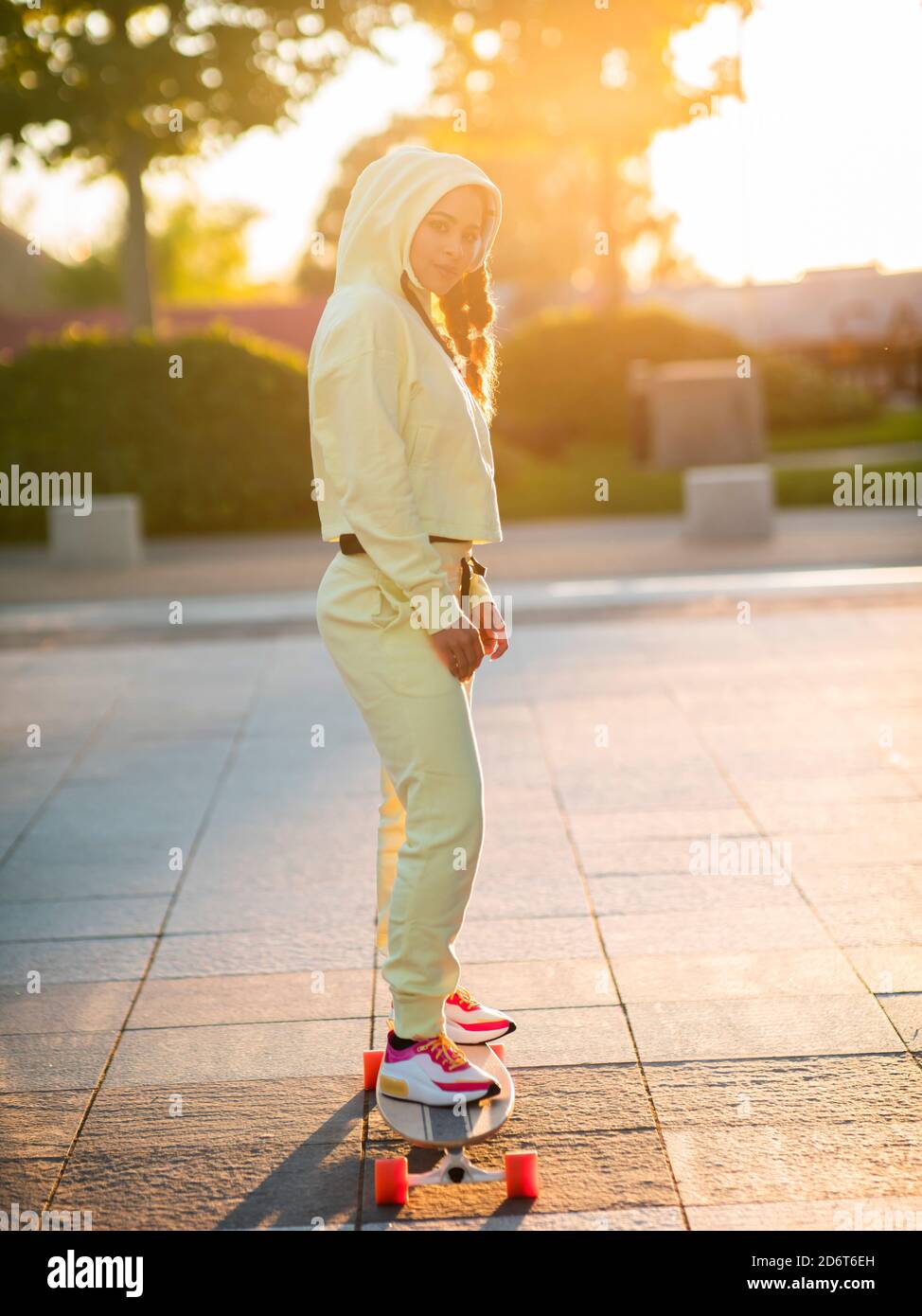 Side view of confident young female in stylish sneakers and activewear ...