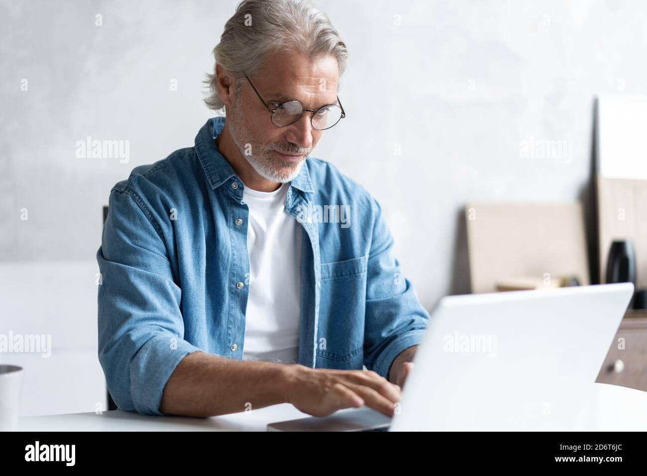 Middle-aged man working from home-office on laptop Stock Photo - Alamy