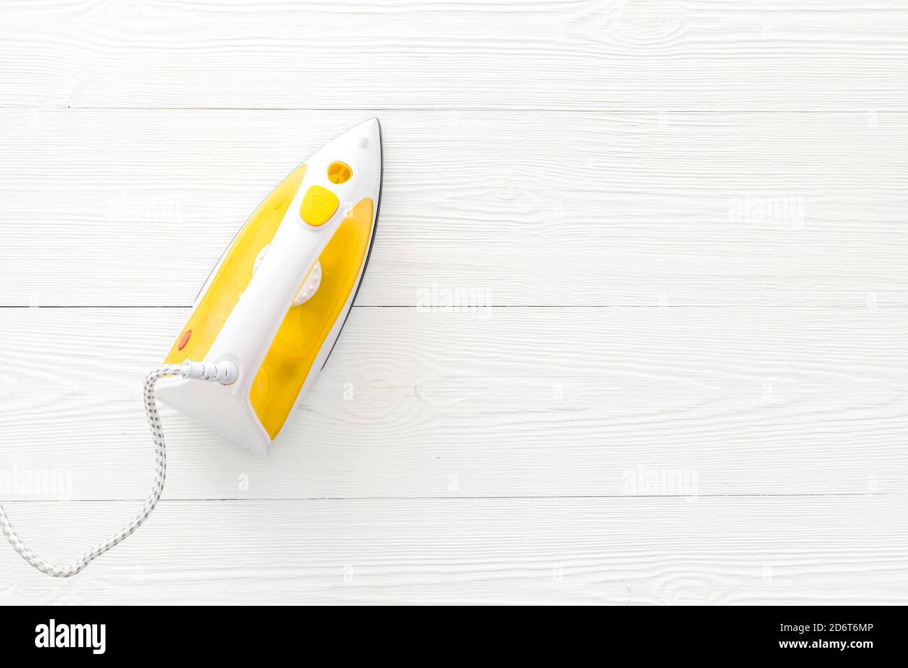 Yellow iron on ironing board. Top view, copy space Stock Photo - Alamy