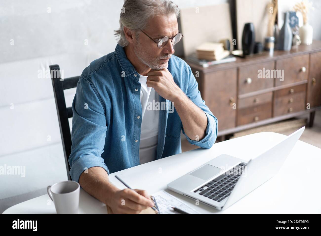 Middle-aged man working from home-office on laptop Stock Photo - Alamy