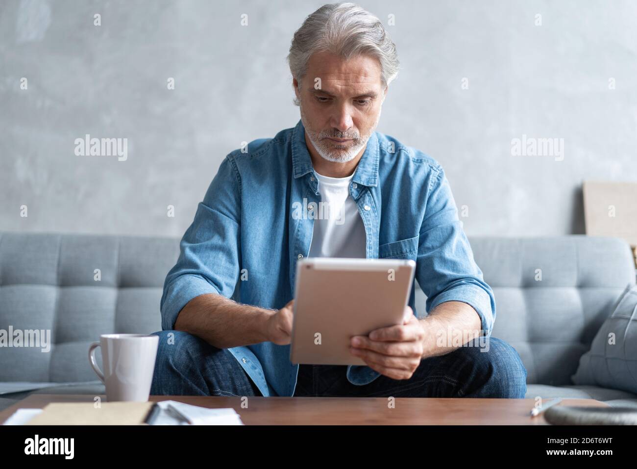 Handsome businessman working on tablet from home Stock Photo - Alamy