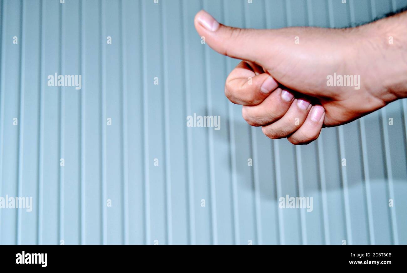 Hand and its shadow and reflection on the patterned wall of OKAY sign ...