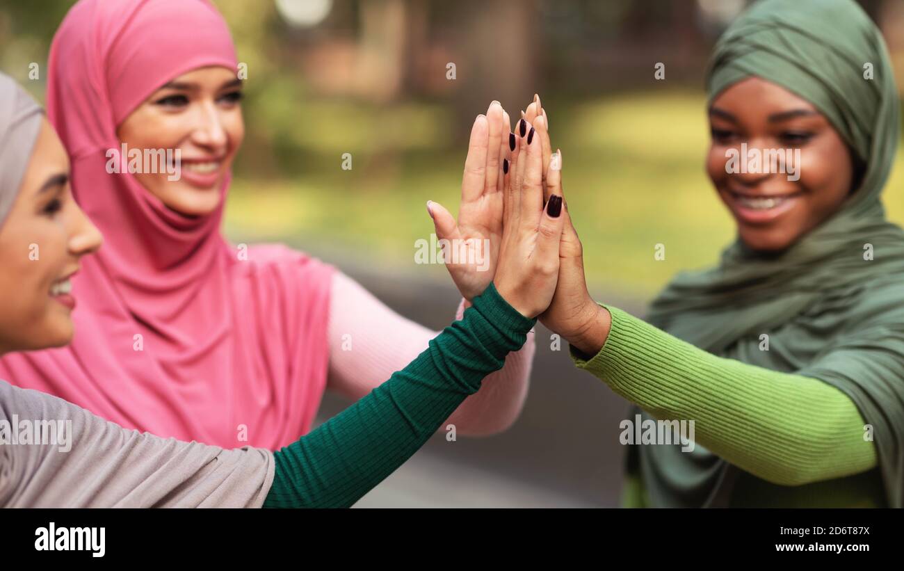 Three Happy Muslim Women In Hijab Giving High-Five Outdoor, Panorama ...