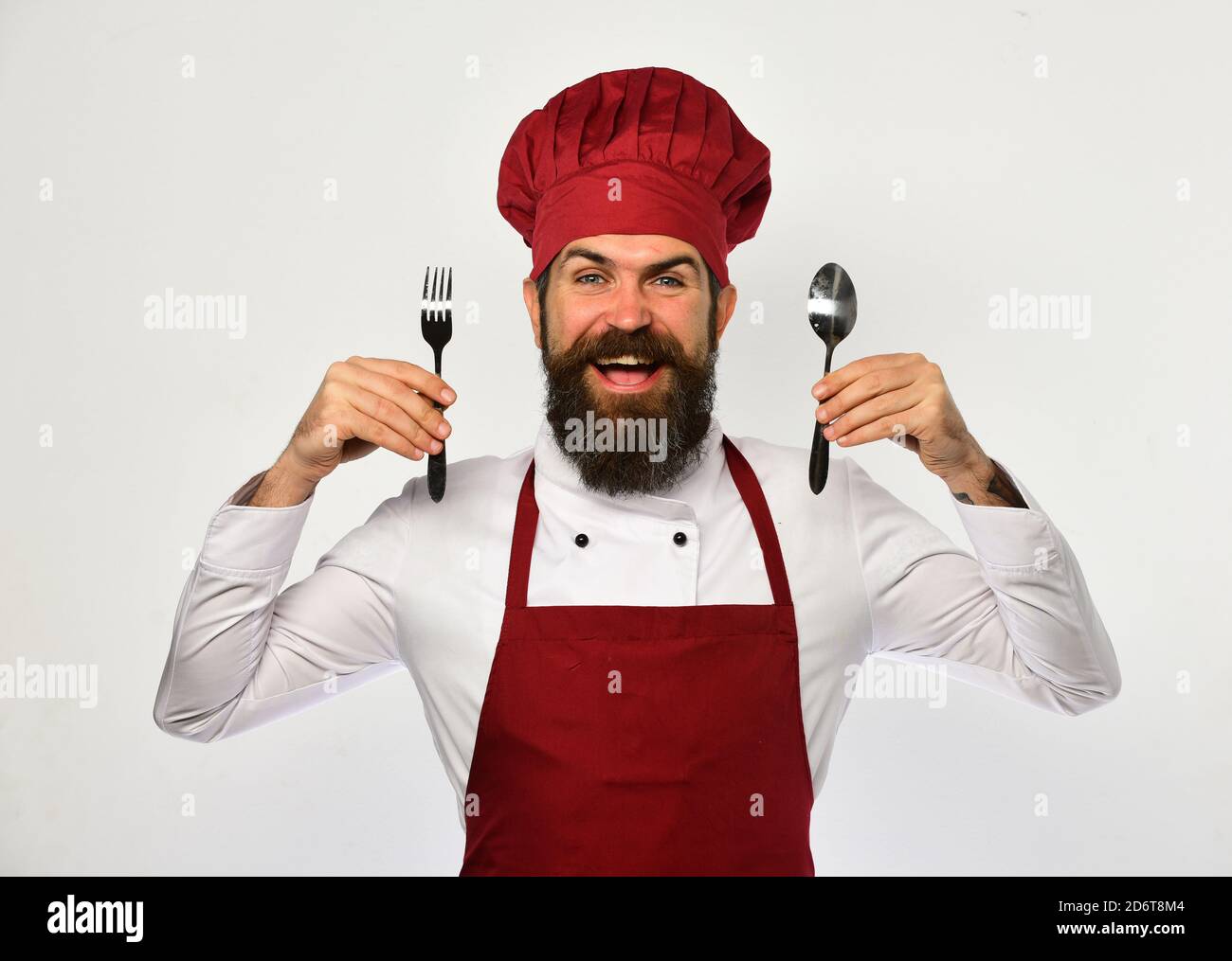 Restaurant utensils concept. Man with beard holds fork and spoon on ...