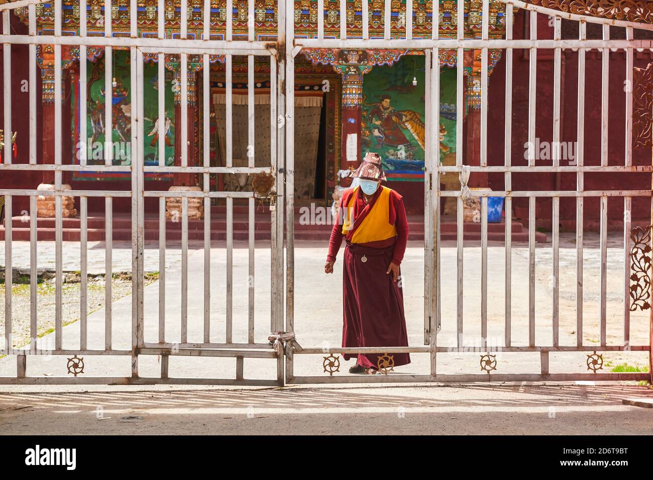 Full body of faceless Tibetan monk in colorful religious garment ...