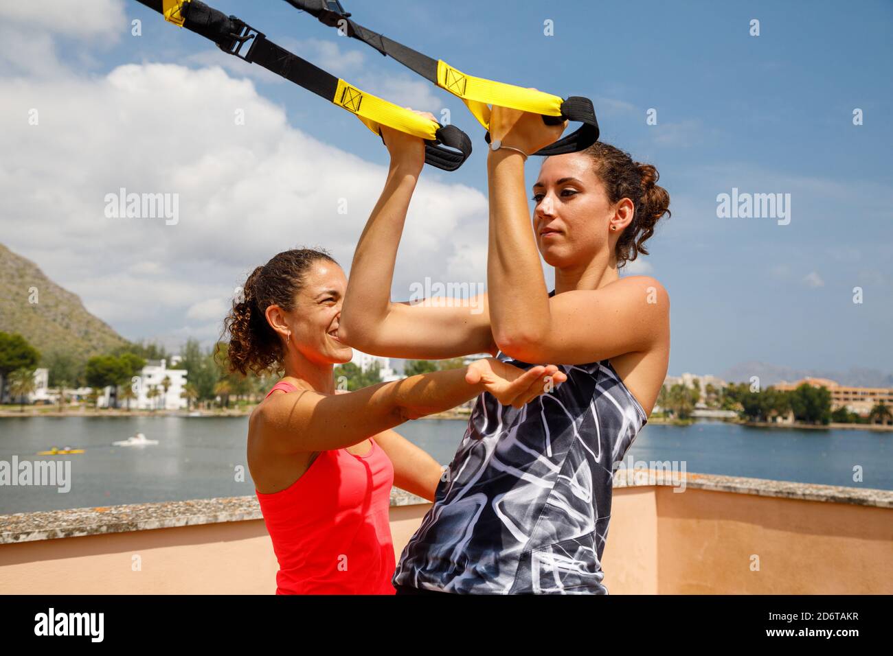 Expressive female trainer supporting concentrated sportsWoman doing ...