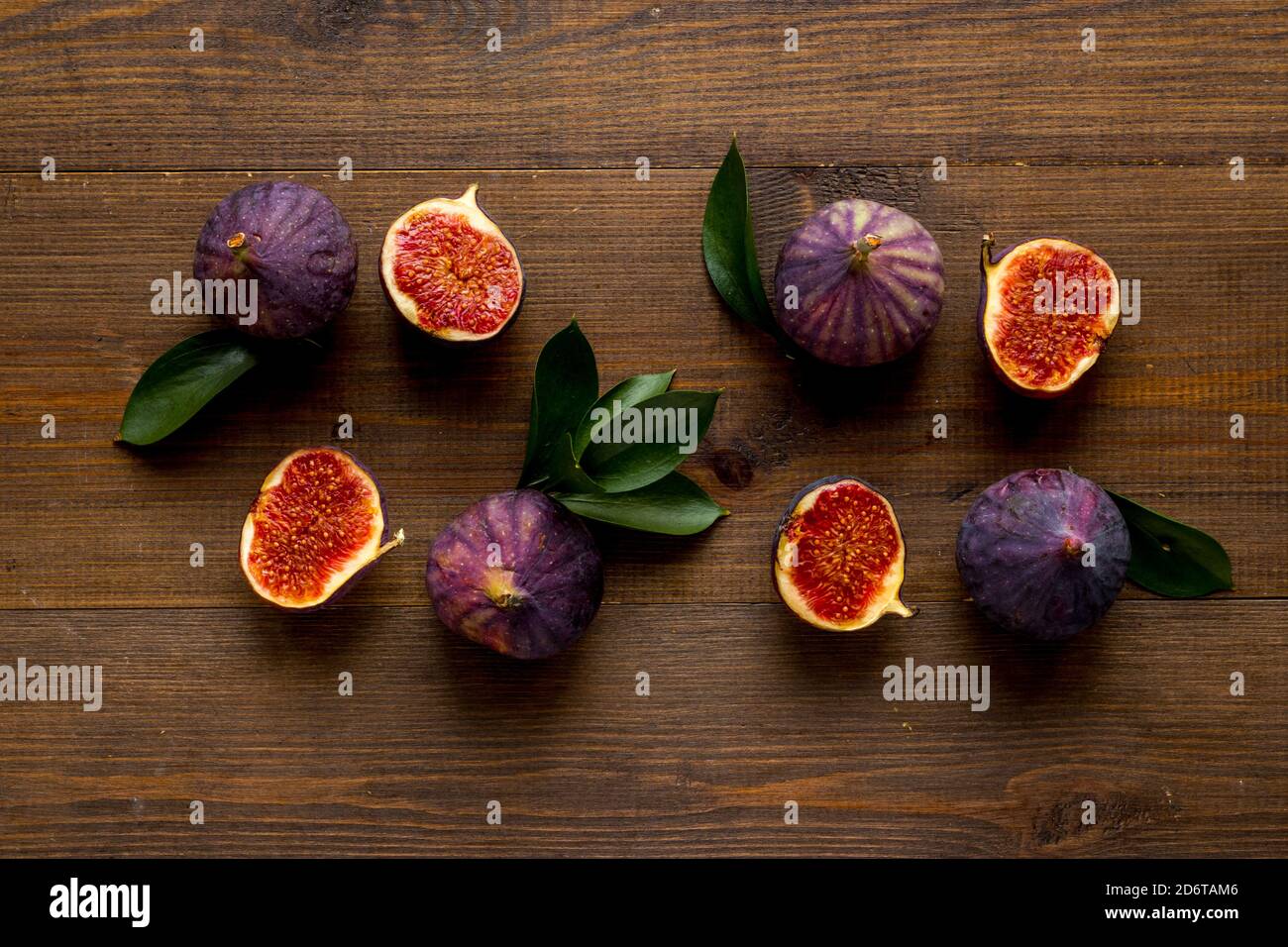 Tasty fresh figs cut in half with leaves, top view Stock Photo - Alamy