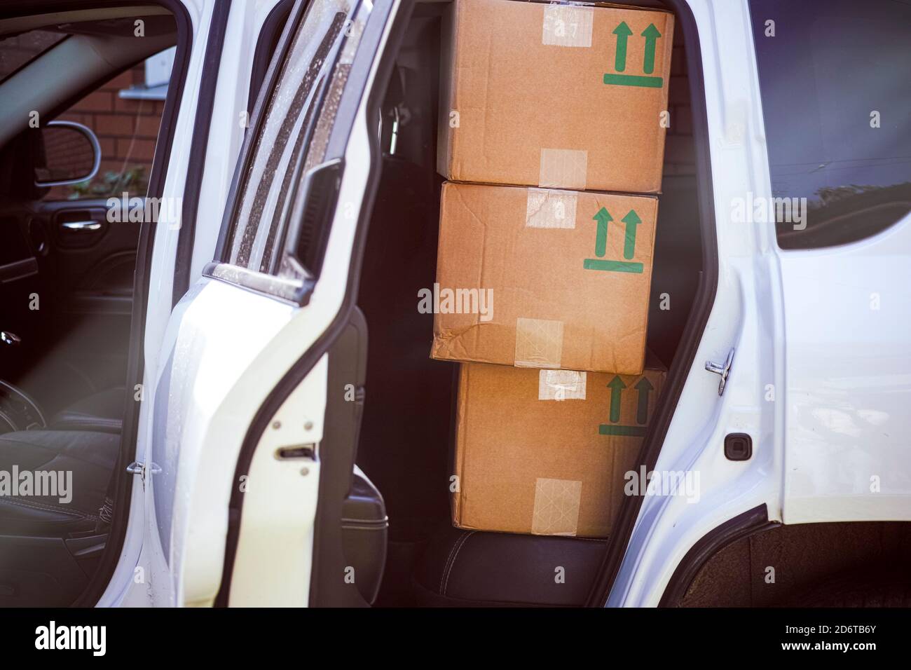 Three cardboard boxes on the back seat of white car Stock Photo - Alamy