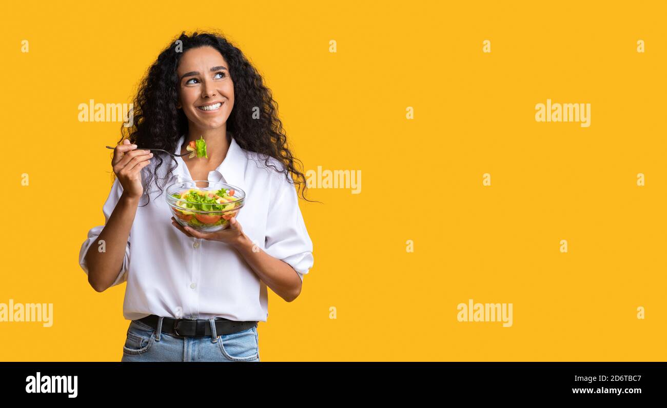 Cheerful Woman Eating Vegetable Salad From Bowl And Looking At Copy ...