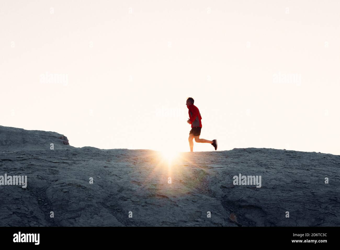 Side view silhouette of unrecognizable athlete running up on mountain ...