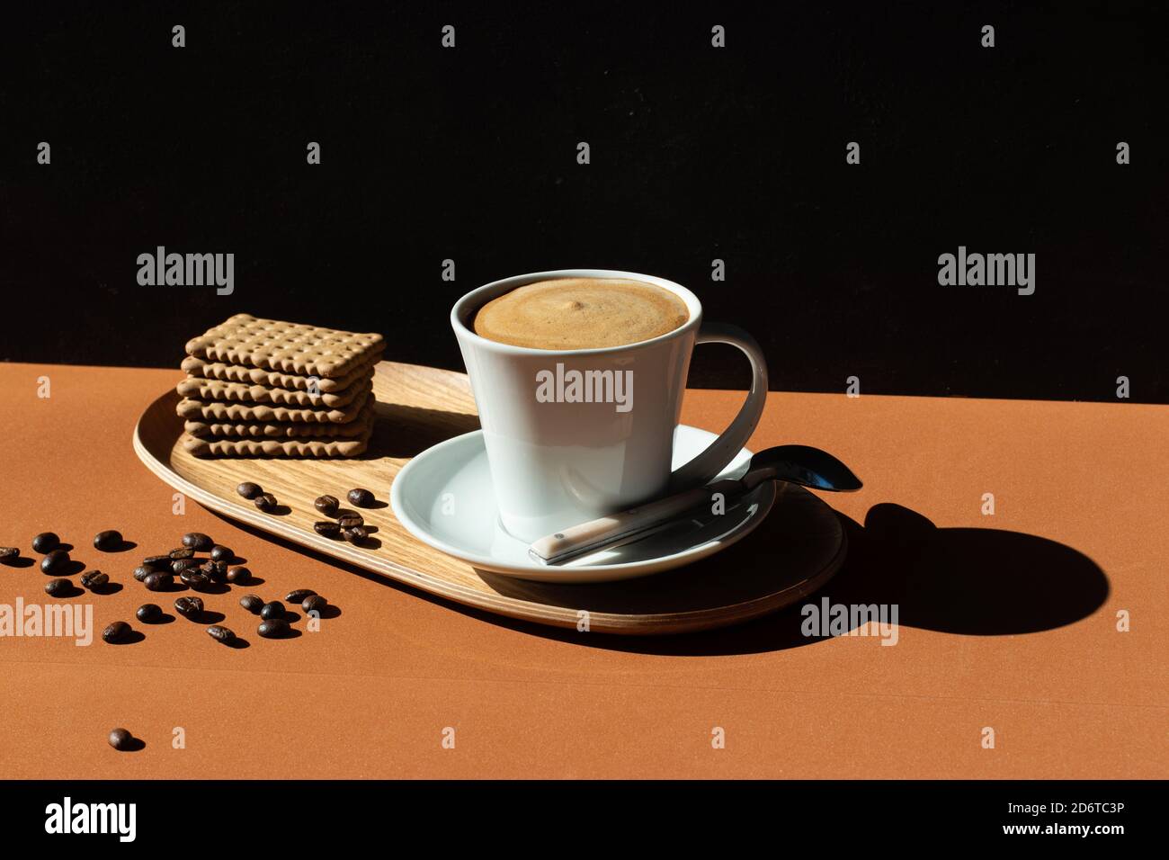 Ceramic cup of tasty coffee near crunchy crackers on wooden plate in ...