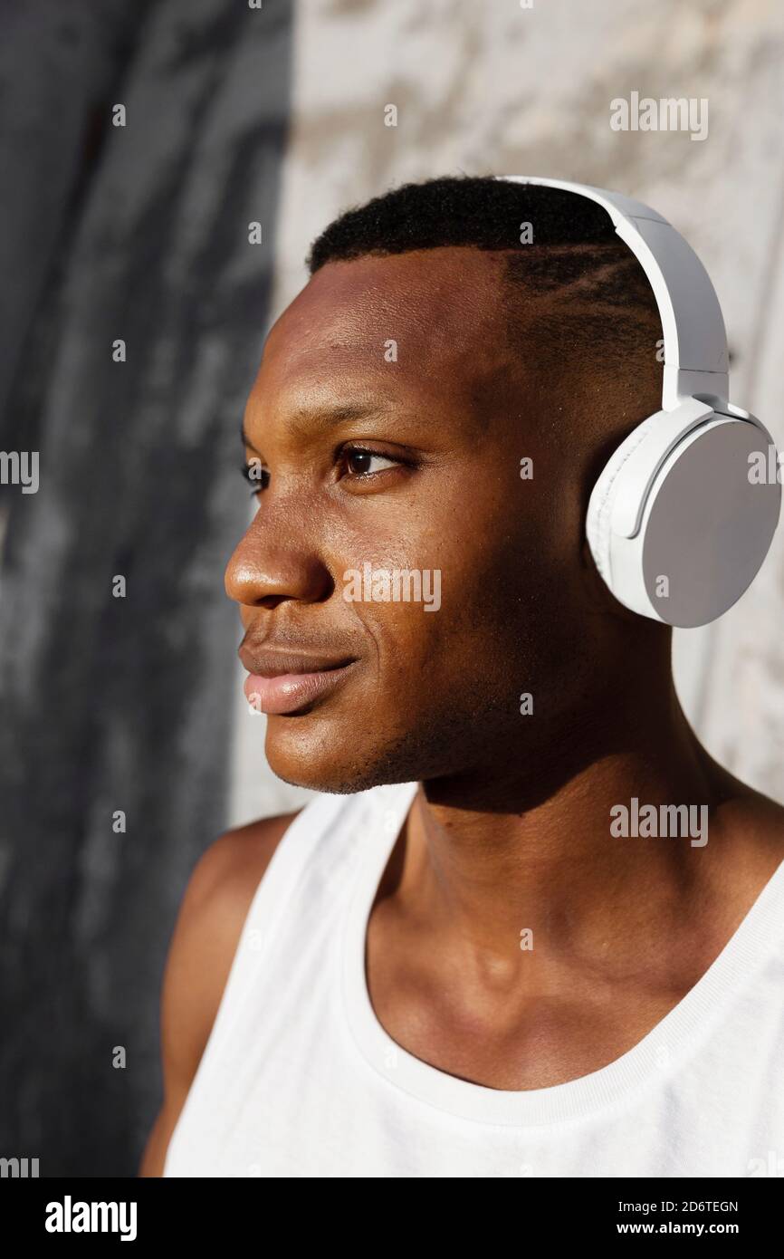 Serious African American male in wireless headphones listening to songs ...