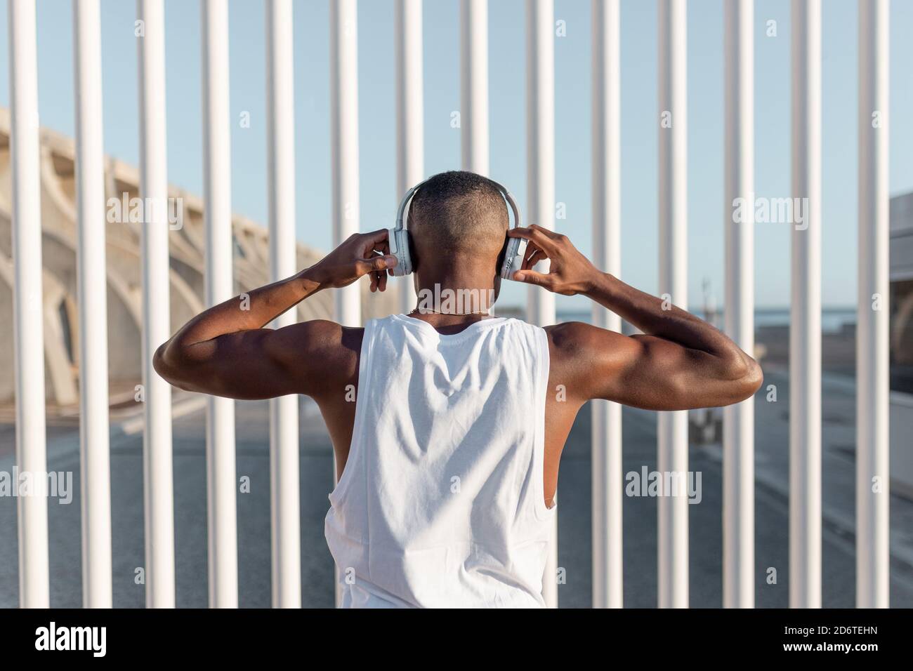 Back view of anonymous African American runner listening to music in ...