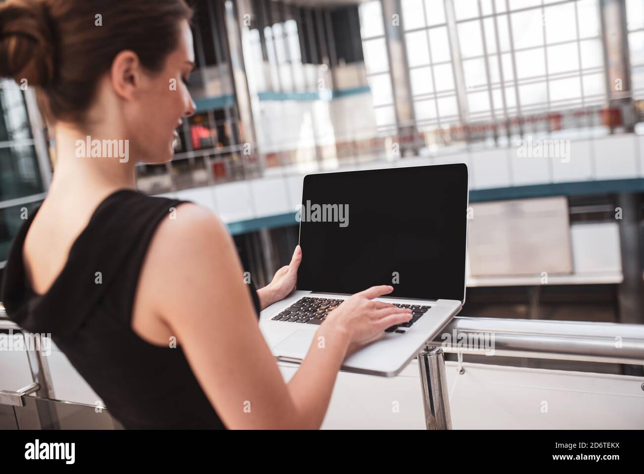Elegant woman working with her computer in the airport Stock Photo - Alamy