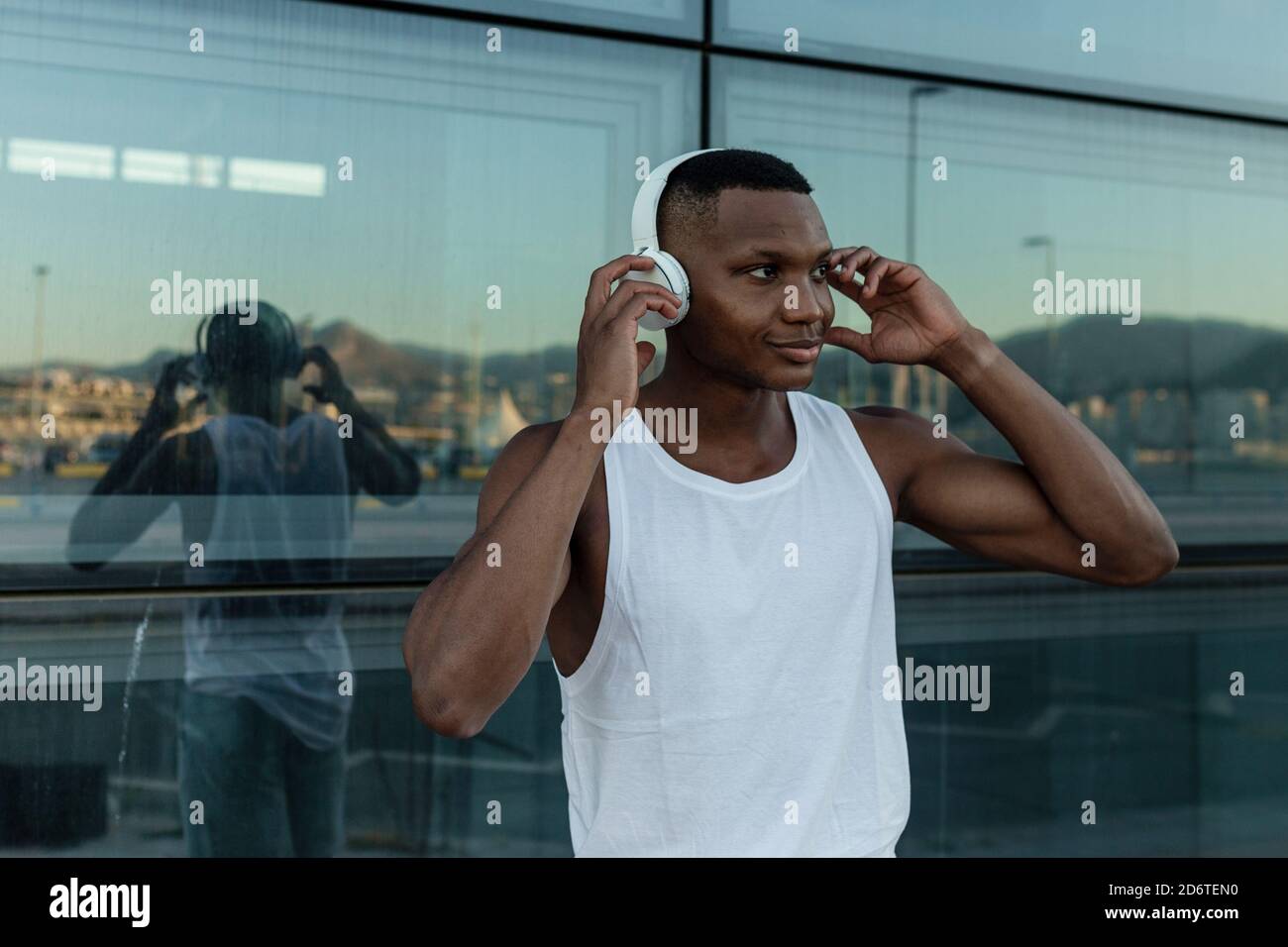 Cheerful African American male athlete smiling while listening to music ...