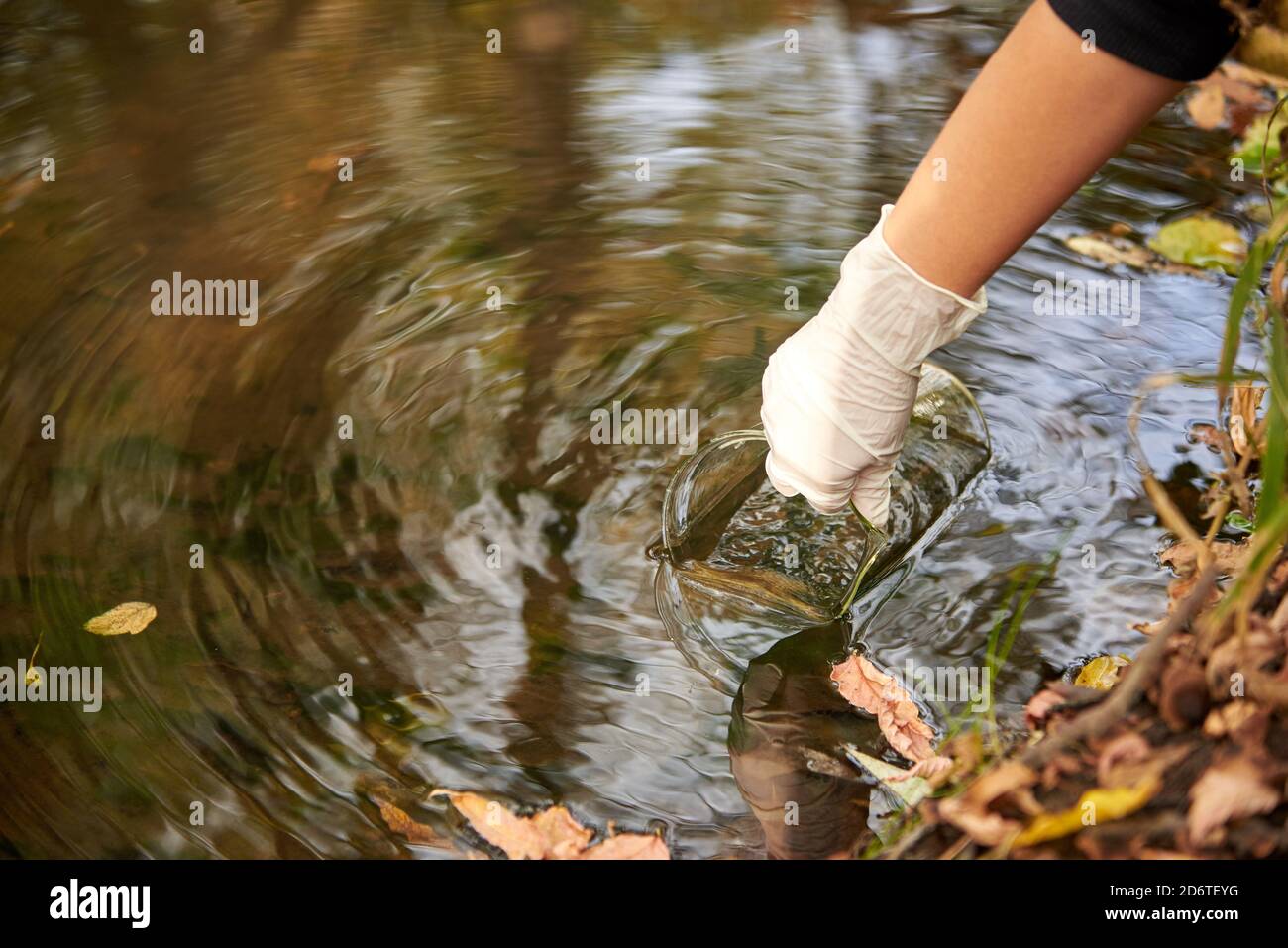 A scientist collects river water in a glass beaker for testing Stock ...