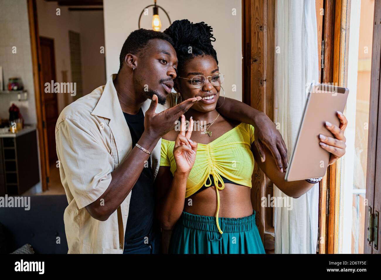 Positive young ethnic man cuddling cheerful girlfriend in crop top ...