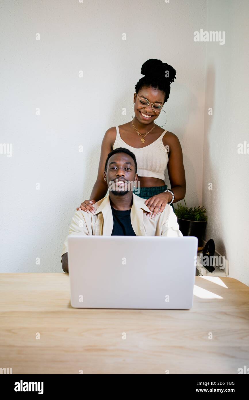 Cheerful African American female in crop top hugging positive husband ...