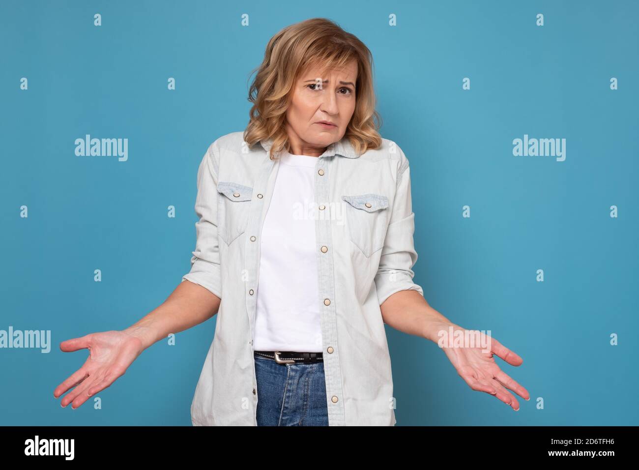 Pretty caucasian mature woman looking confused shrugging shoulders ...